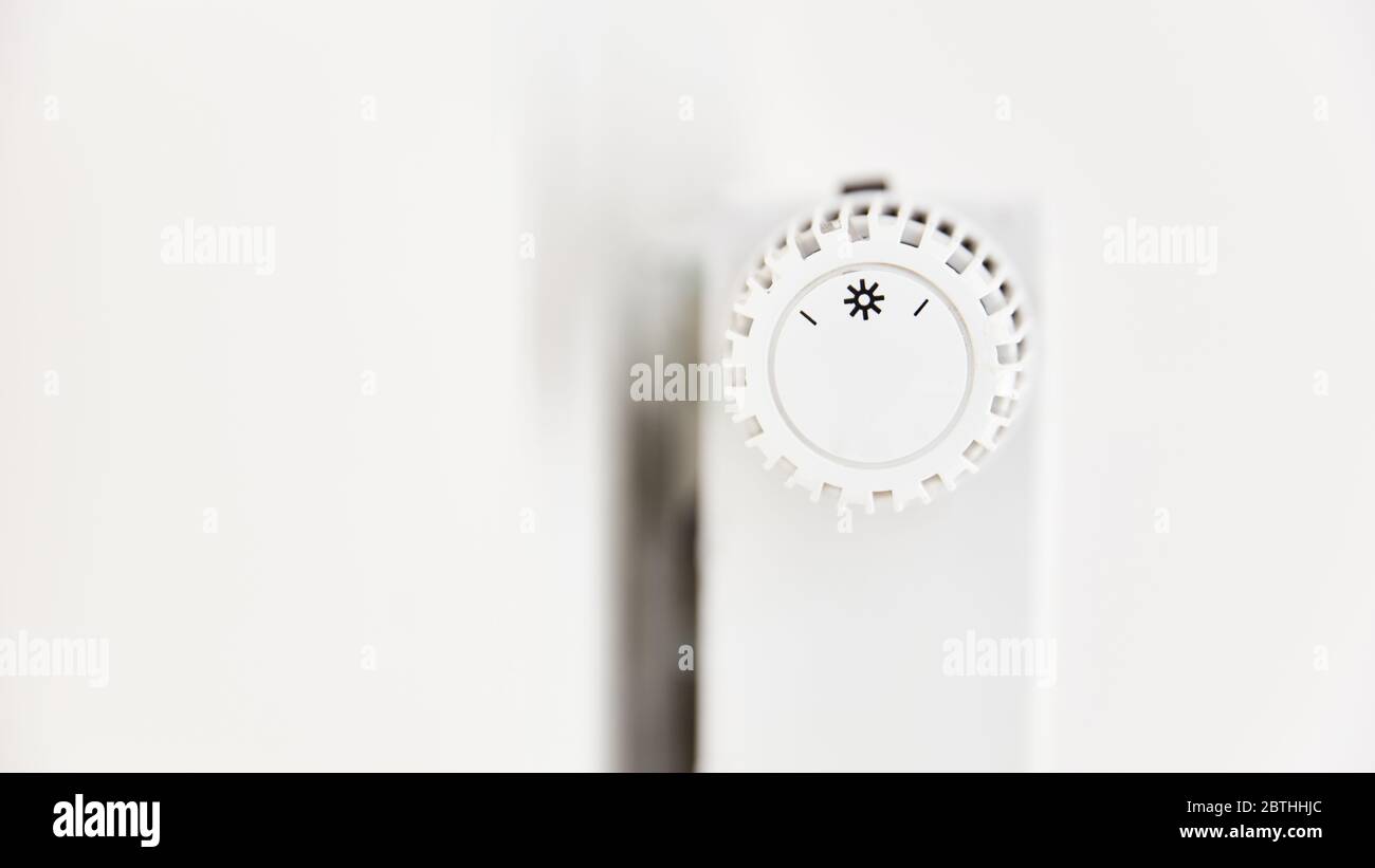 White thermostat and temperature controller on heating with radiator ...
