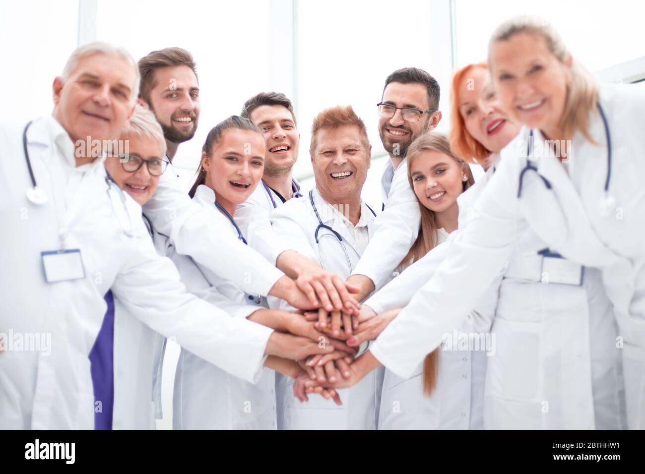large group of doctors put their hands together Stock Photo - Alamy