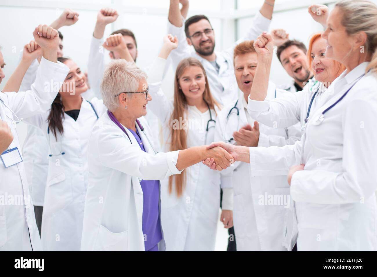 happy medical colleagues congratulating each other on their success ...