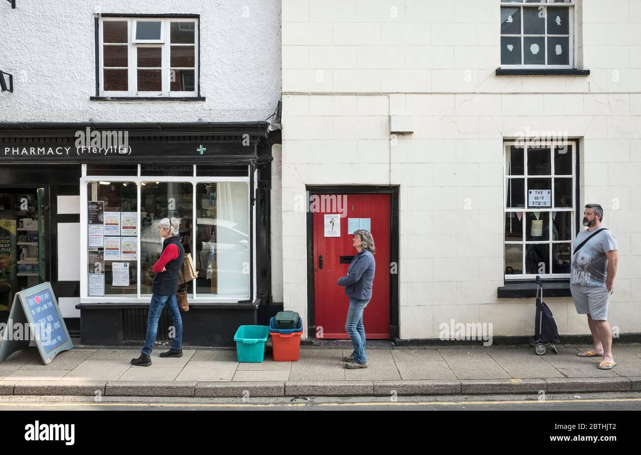 A queue maintaining safe social distancing outside the local pharmacy ...