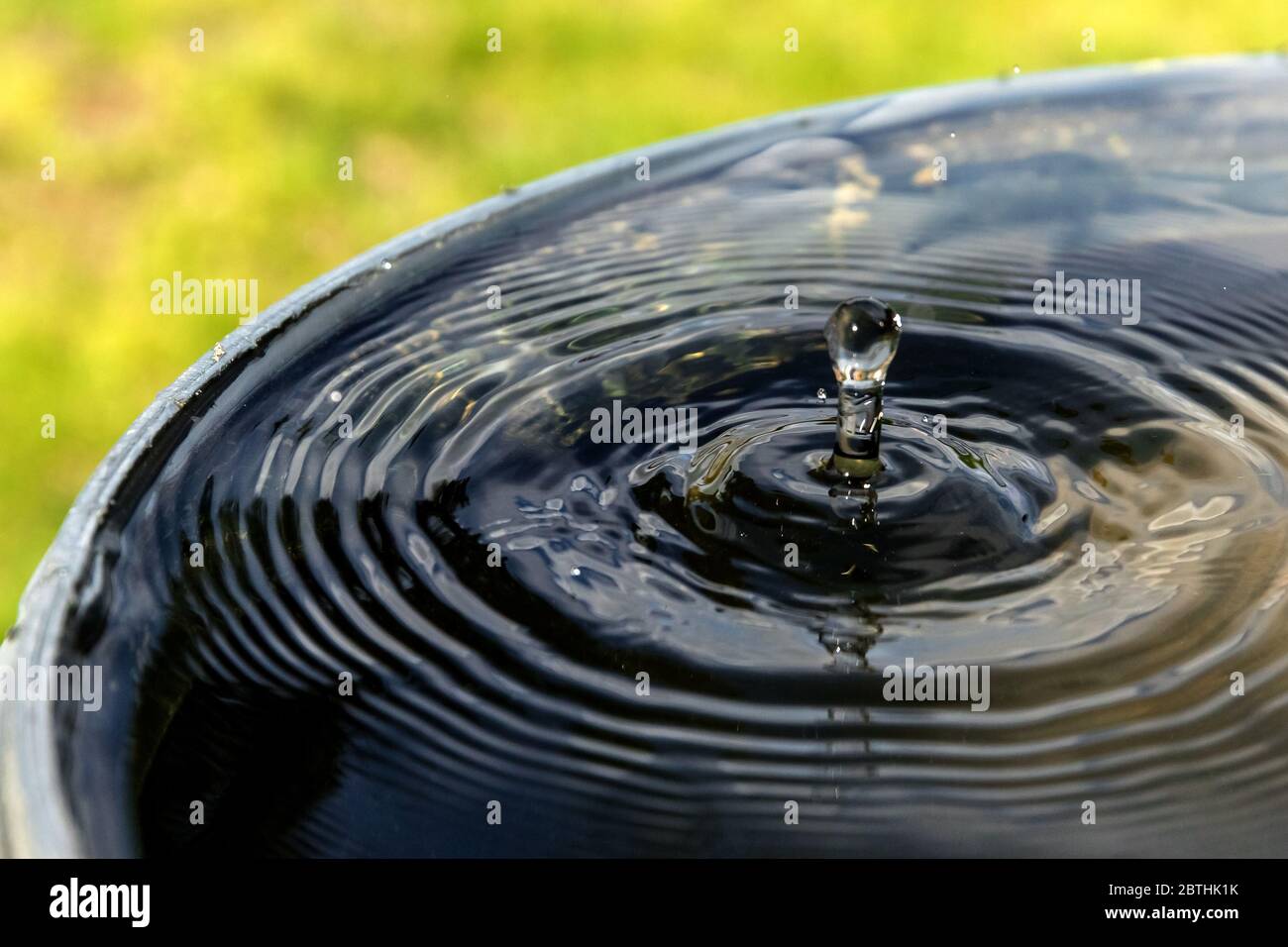 Impact of a drop of rainwater on a full barrel. Saving water on the ...