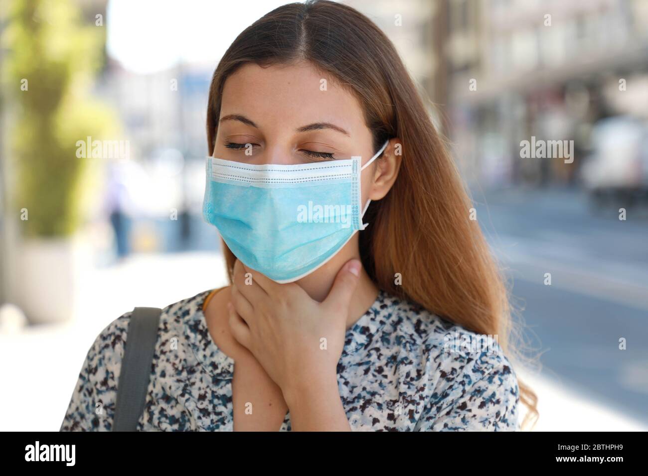COVID-19 Close up Woman wearing surgical mask with sore throat outdoor ...