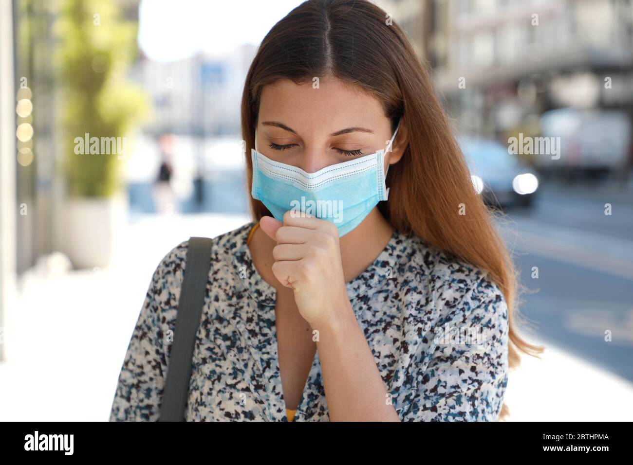 COVID-19 Close up sick woman wearing surgical mask coughing in city ...