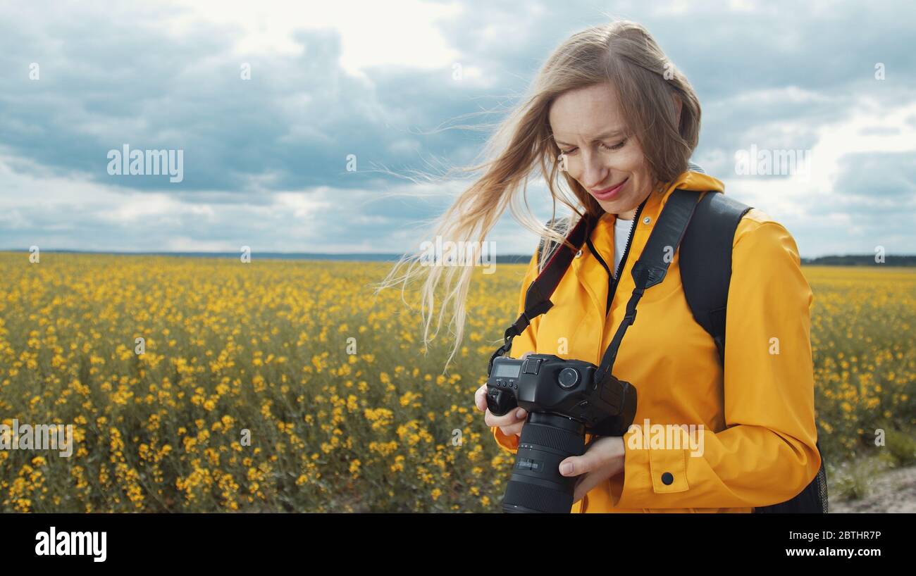Woman looking pictures on dslr Stock Photo - Alamy