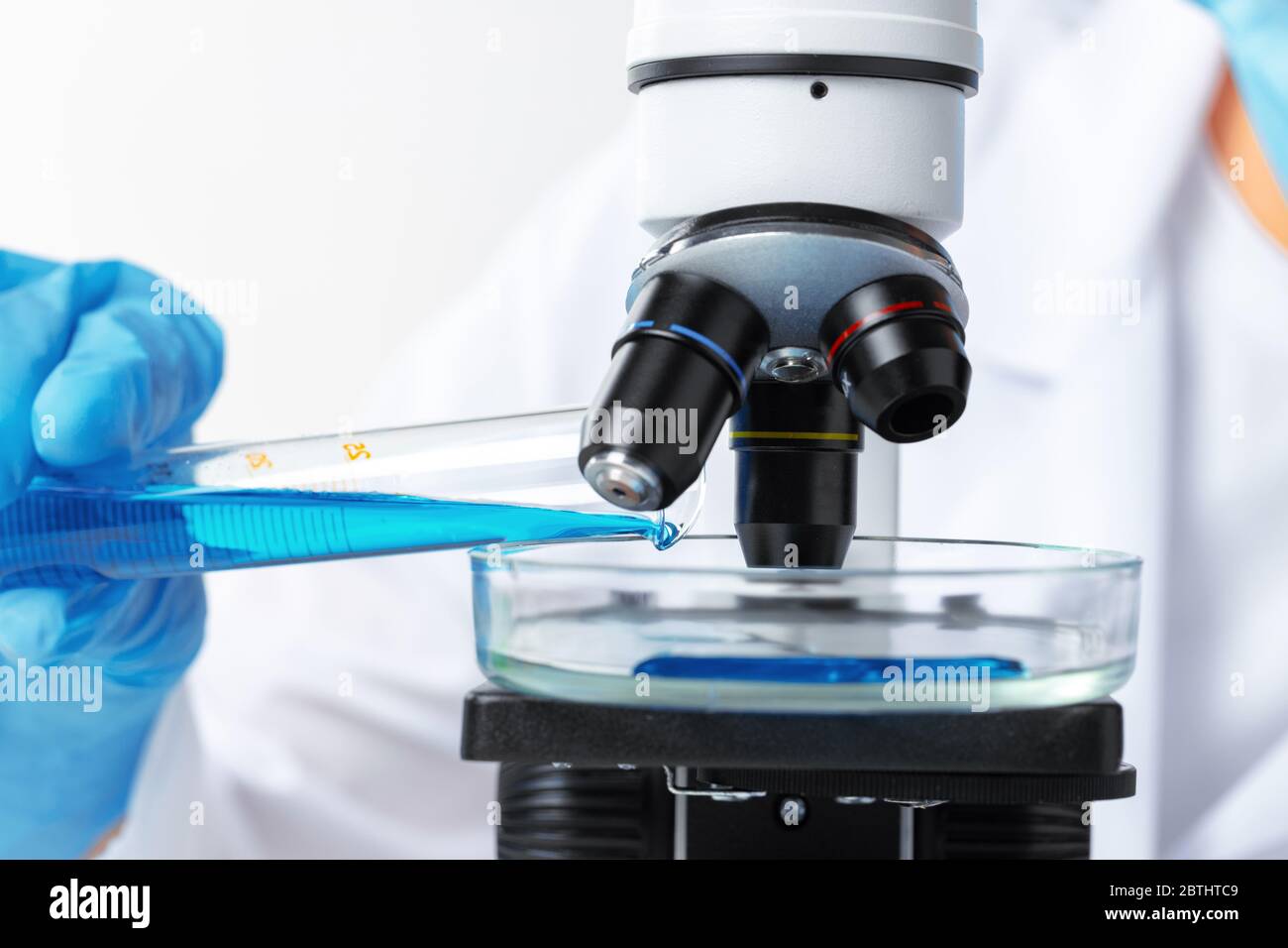 Scientist's hands doing chemical research with the help of microscope ...