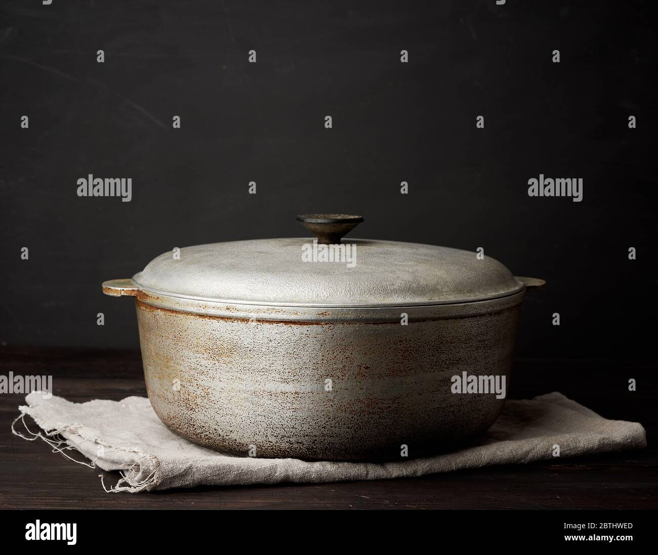 aluminum old cauldron on a wooden table, kitchen utensils Stock Photo ...