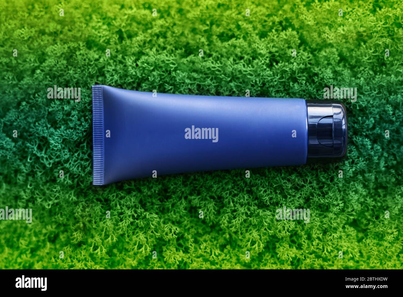 dark blue tube of cream. Lying on green moss. View from above Stock ...