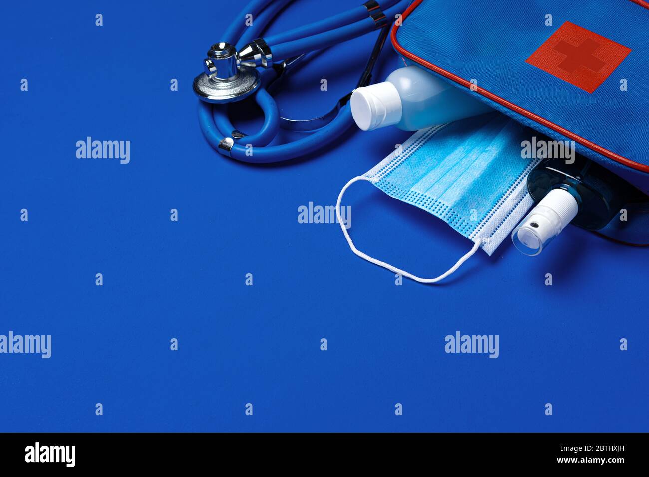First aid kit with mask and sanitizer on blue background Stock Photo ...