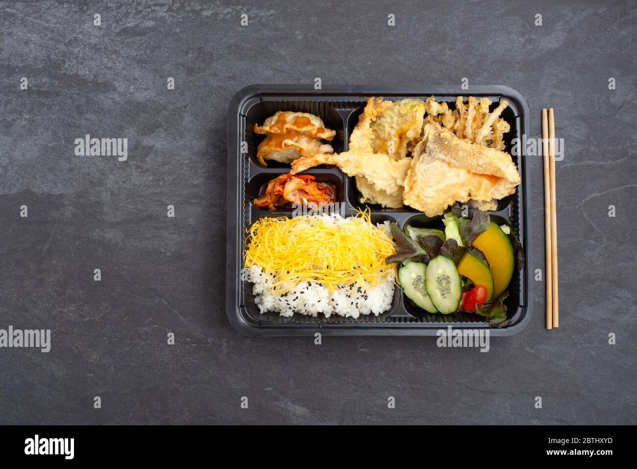 Japanese bento set with salmon and shrimp tempura on dark stone ...