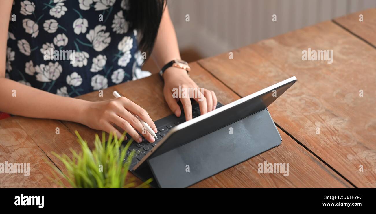 Cropped image of stylish woman holding a stylus pen and typing on ...