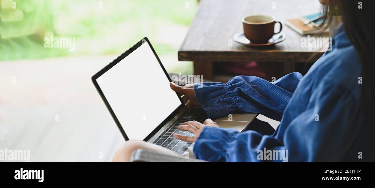 Photo of beautiful woman typing on white blank screen computer laptop ...
