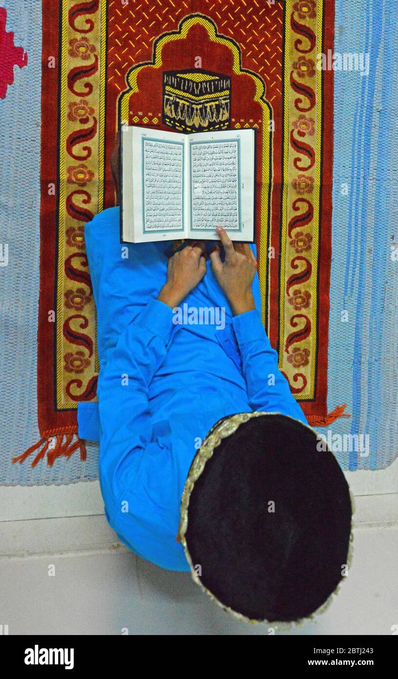 Muslim boy read the holy Quran as he offer namaz on Jumat-Ul-Wida at ...