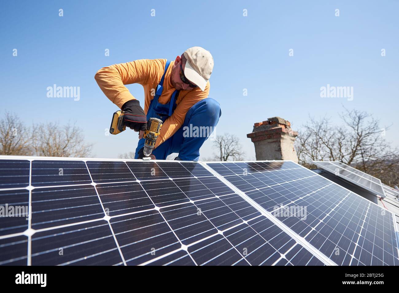 Male engineer installing stand-alone solar photovoltaic panel system ...