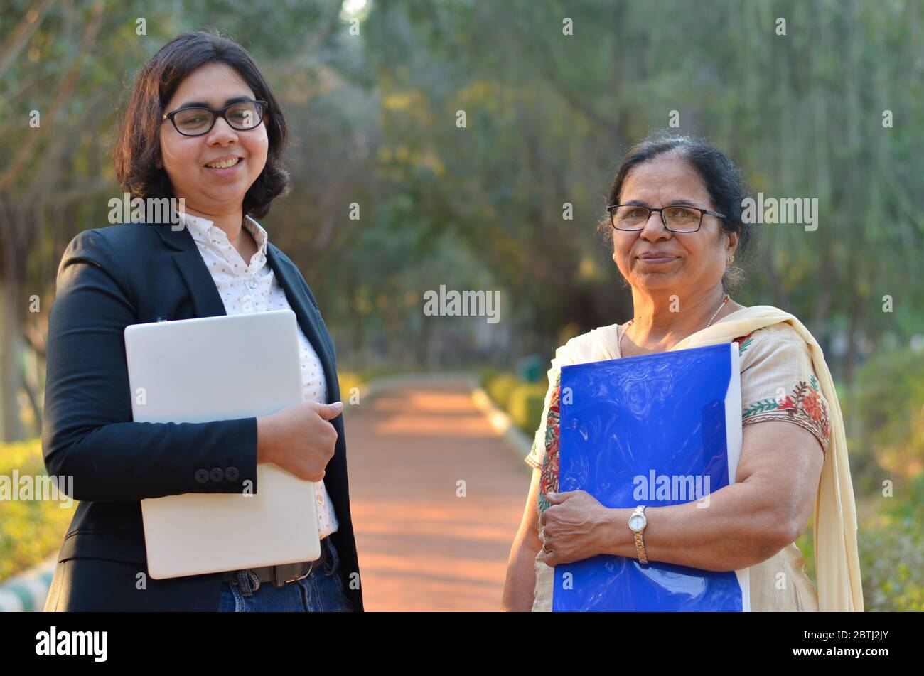 Young Indian entrepreneur woman and her old retired mother standing ...