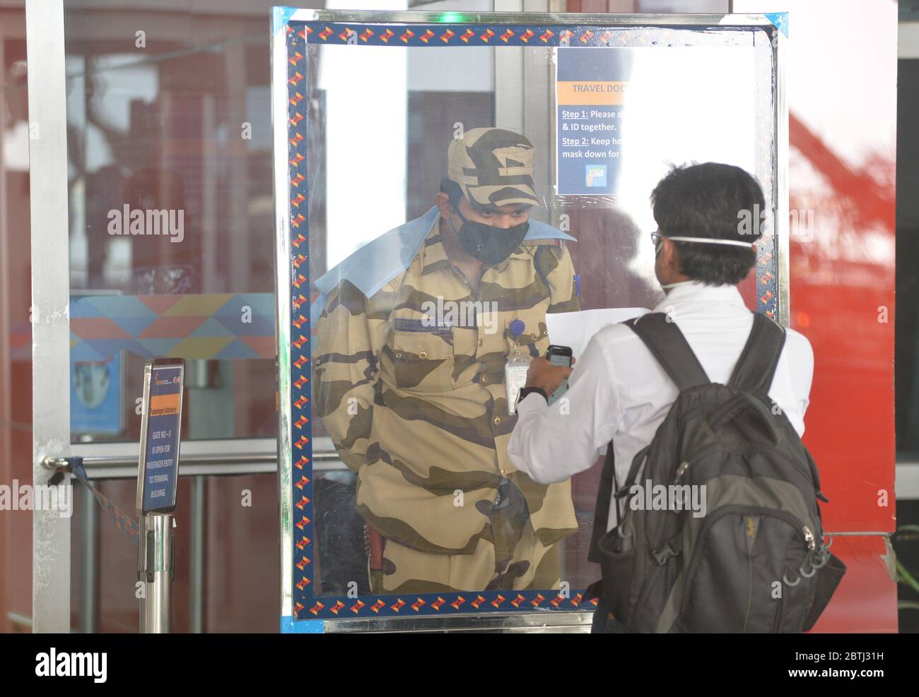 A security guard checks credentials of a passenger standing behind a ...