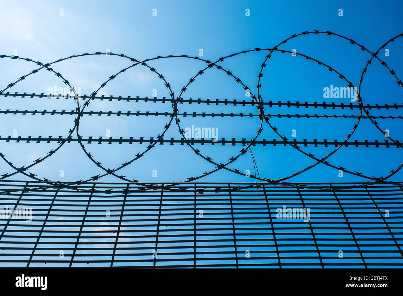 High wire Fence with a barbed wire on top UK Stock Photo - Alamy