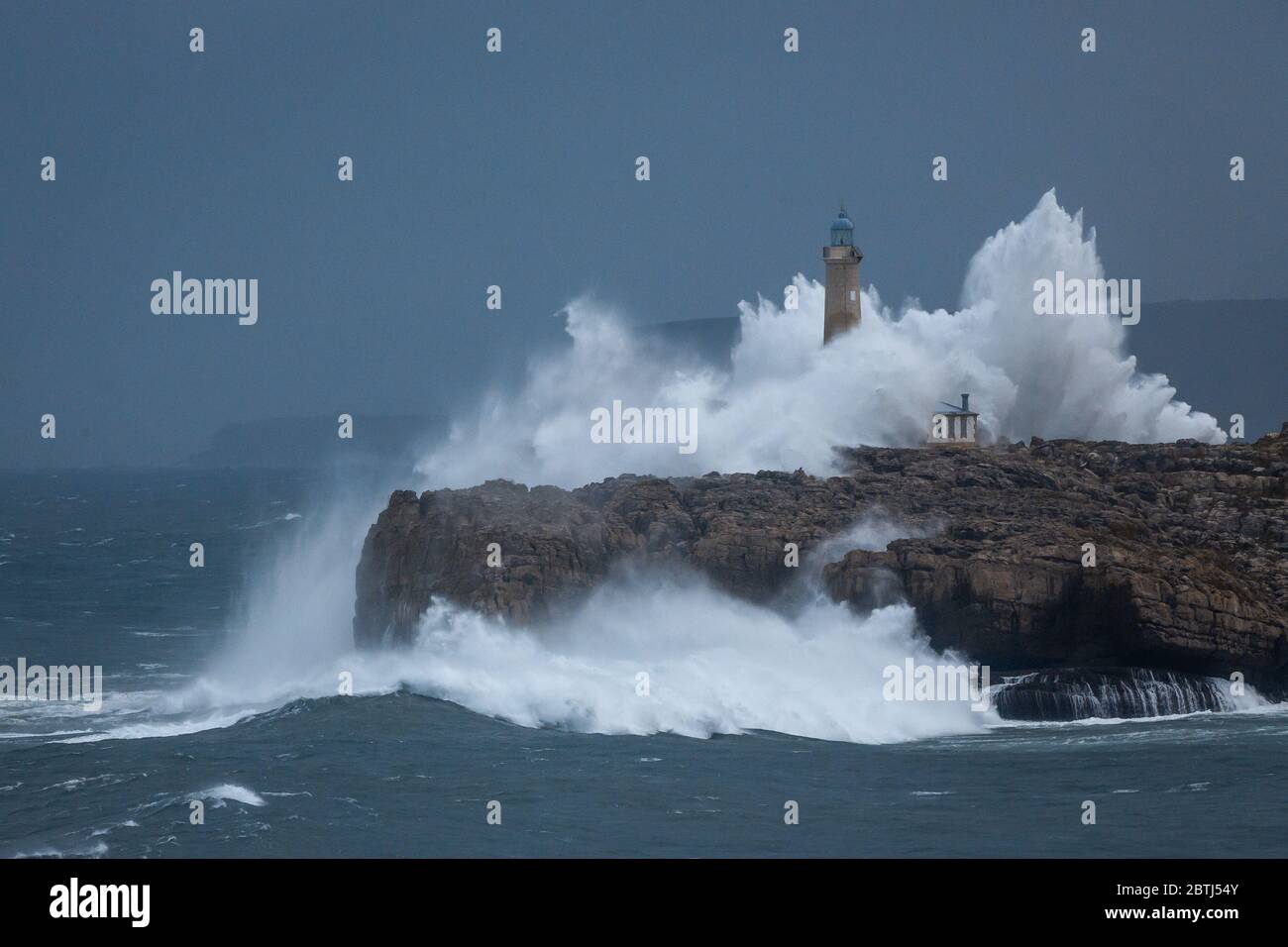 Lighthouse on the island of Mouro, in Santander, hit by the waves of a ...