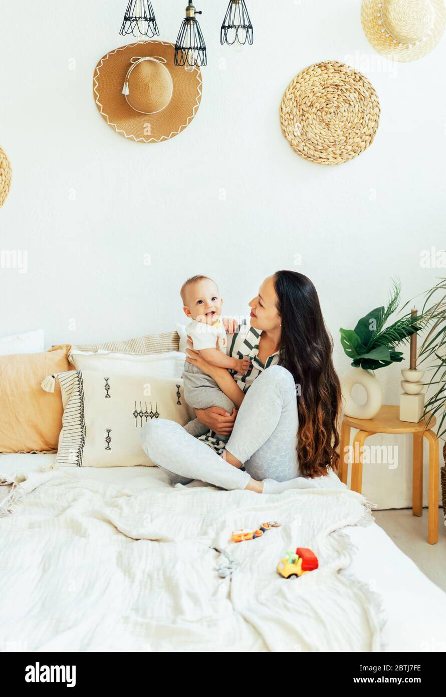 mom and baby cuddle on the bed Stock Photo - Alamy