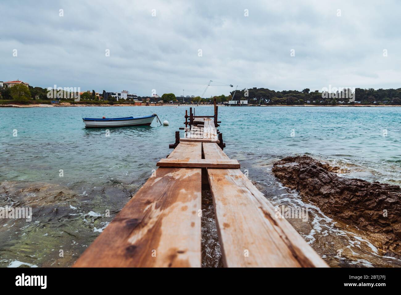 view of small fishing pier with boat near it Stock Photo - Alamy