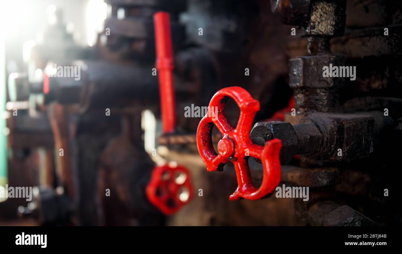 Closeup image of old valve with stained paint on steam powered engine ...