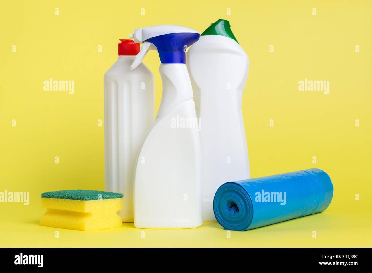 Three cans of cleaning spray with a scouring pad and garbage bags ...
