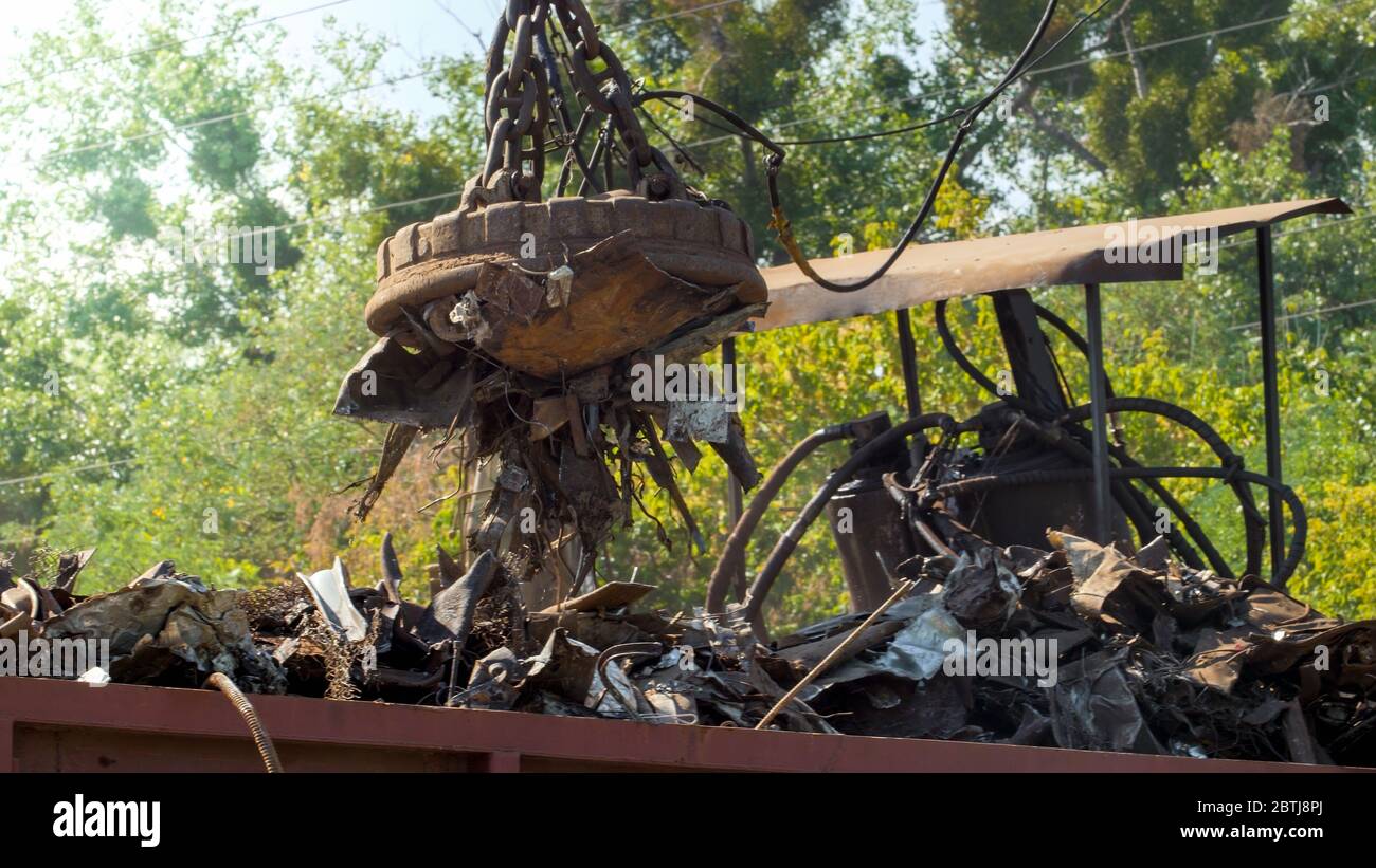 Image of metal scrap and waste stcking to the electric magnet on dump ...