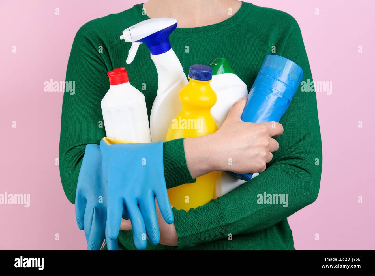 woman with green sweater and pink background hugging many cleaning ...