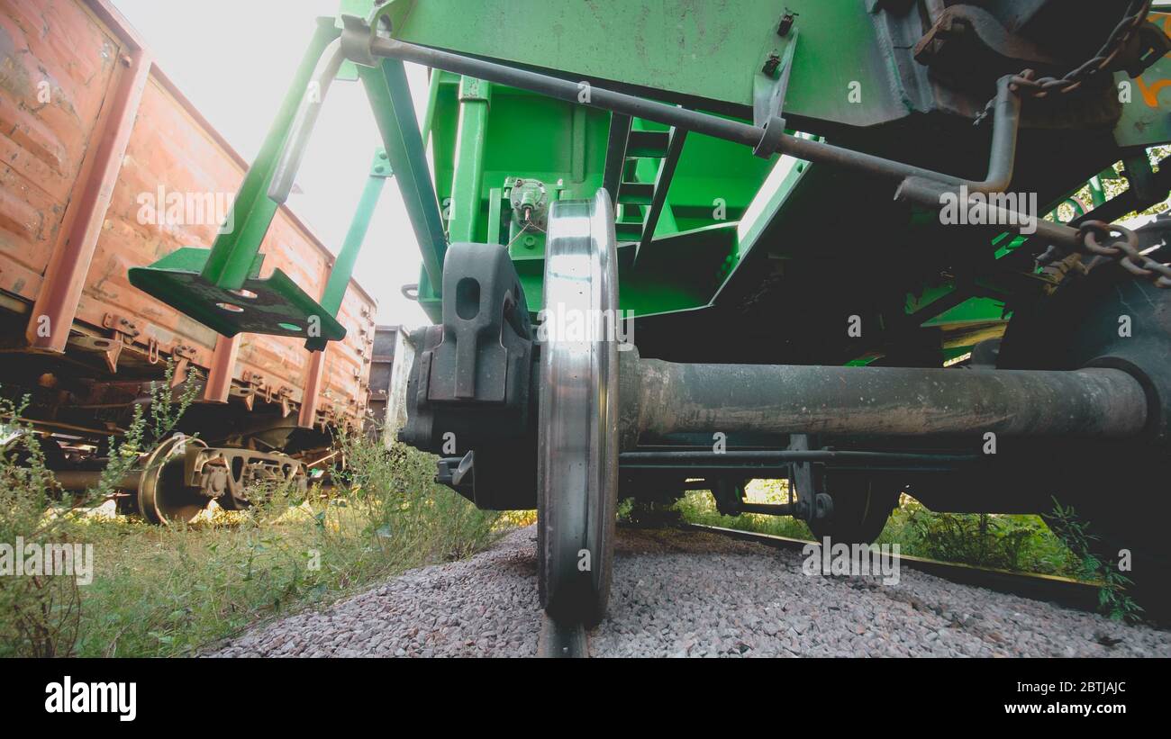 Toned closeup image of massive metal wheels and axle on cargo train car ...