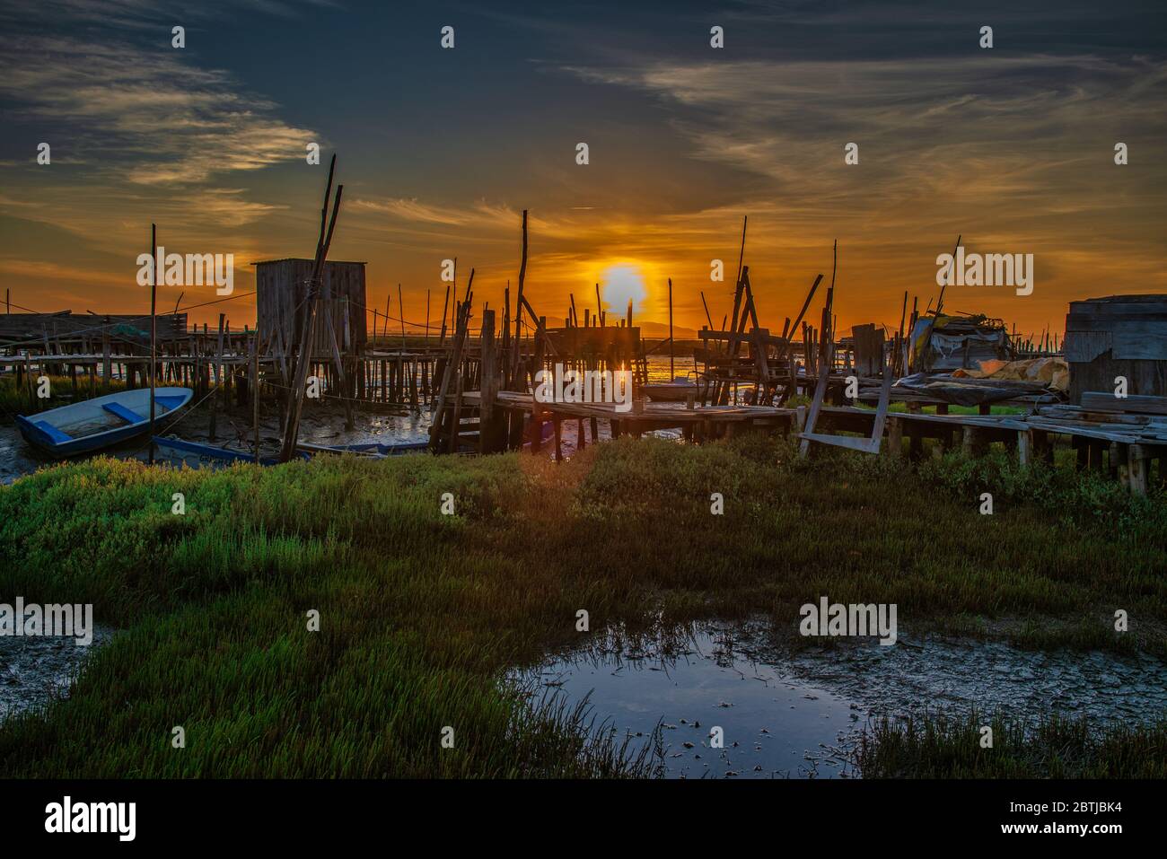 Golden sunset over the traditional stilt pier of Carrasqueira, with ...