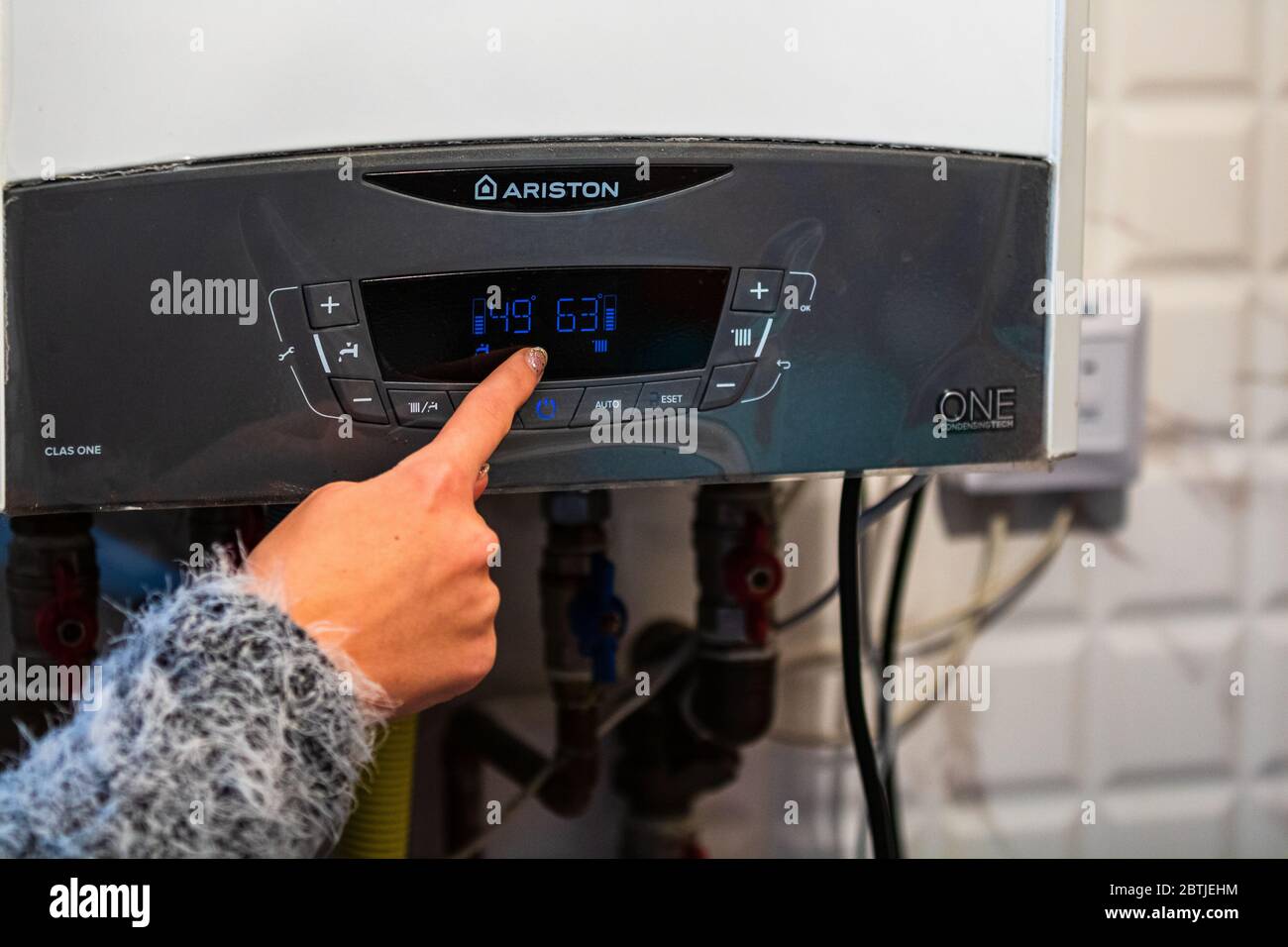 Girl hand setting temperature to heating system. Central heating ...