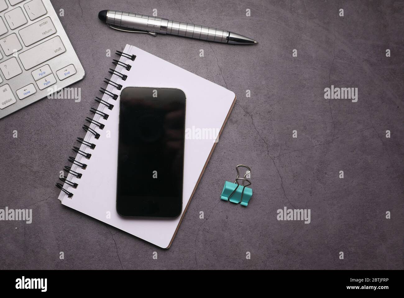 smart phone with empty screen, notepad and keyboard on gray gray ...