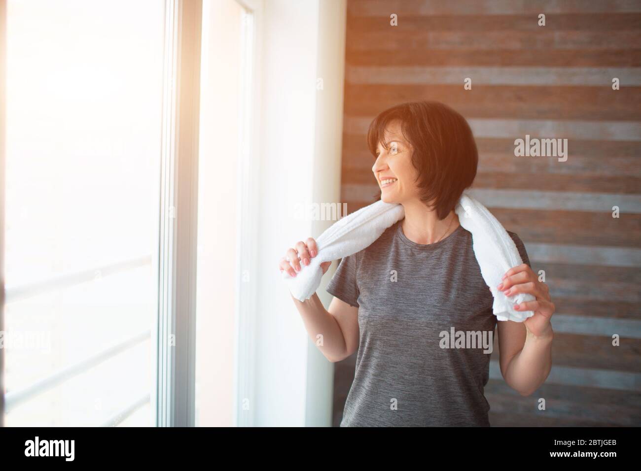 Adult fit slim woman has workout at home. Well-built strong senior ...