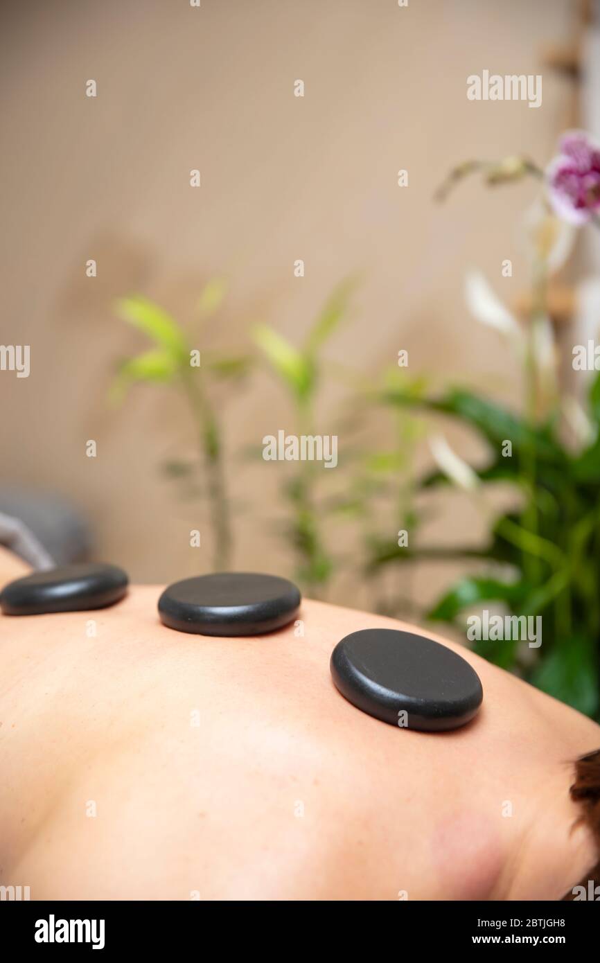 Young woman have a health spa relaxing stone therapy with hot volcanic ...
