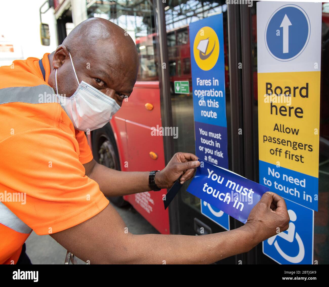 Arriva bus garage staff installing stickers on London buses remind ...