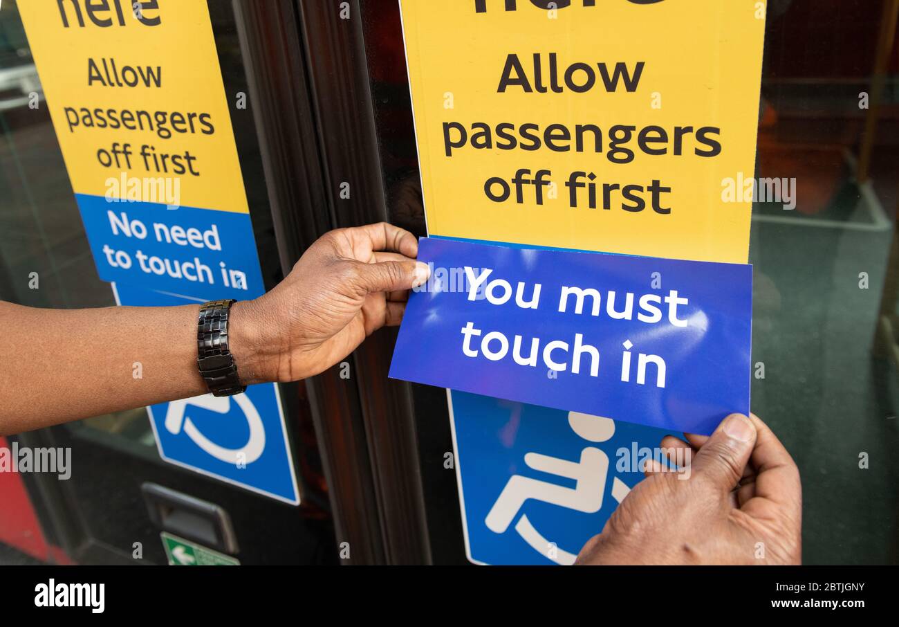 Arriva bus garage staff installing stickers on London buses remind ...