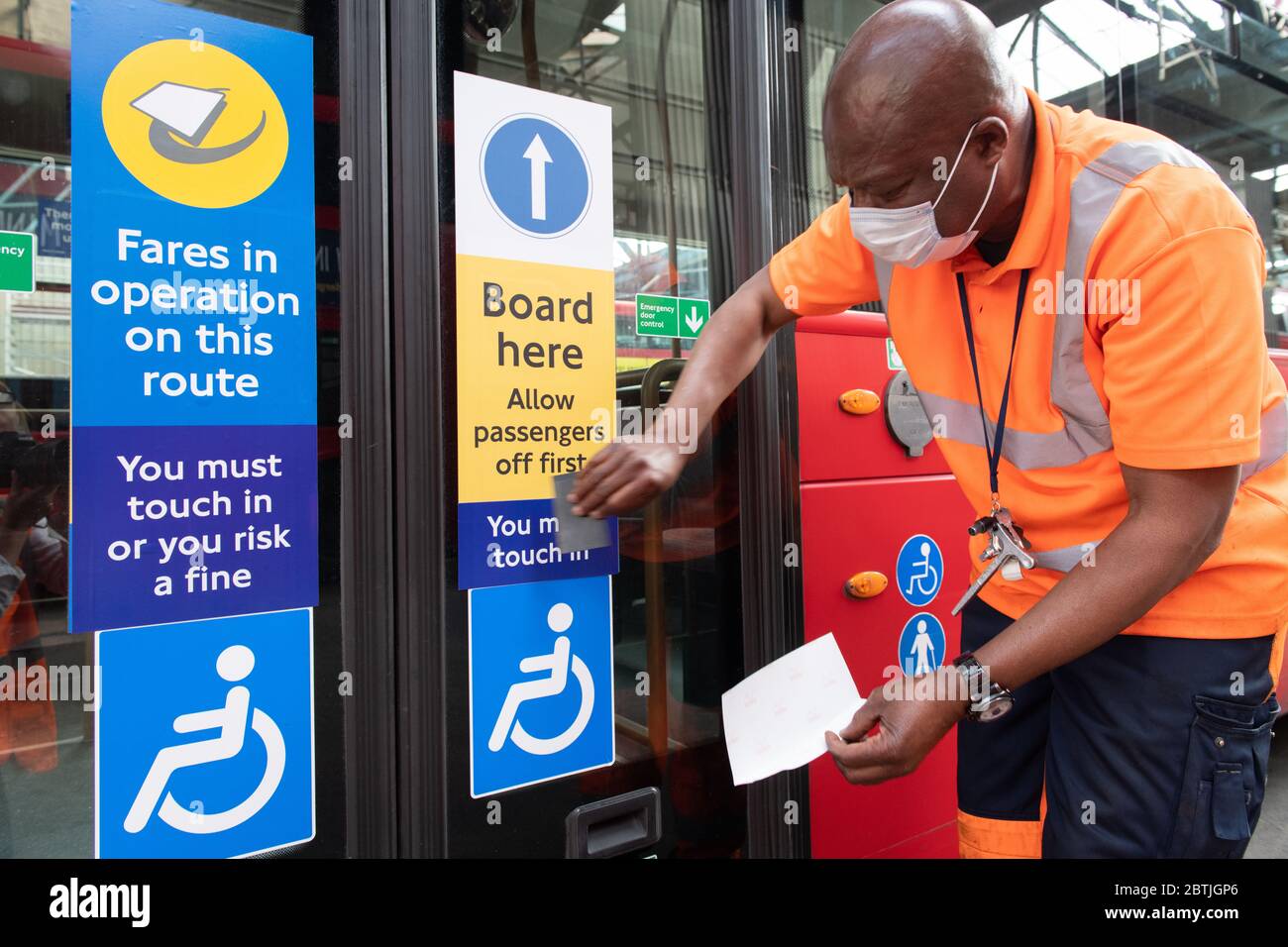 Arriva bus garage staff installing stickers on London buses remind ...