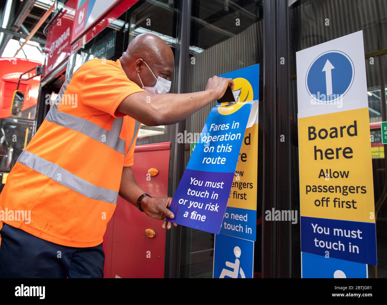 Arriva bus garage staff installing stickers on London buses remind ...