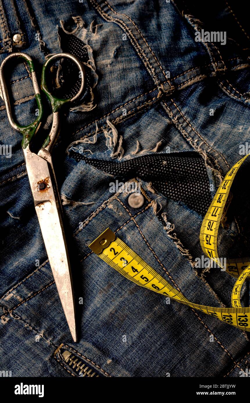 Tailoring and design concept. Scissors, measuring tape and ripped jeans ...