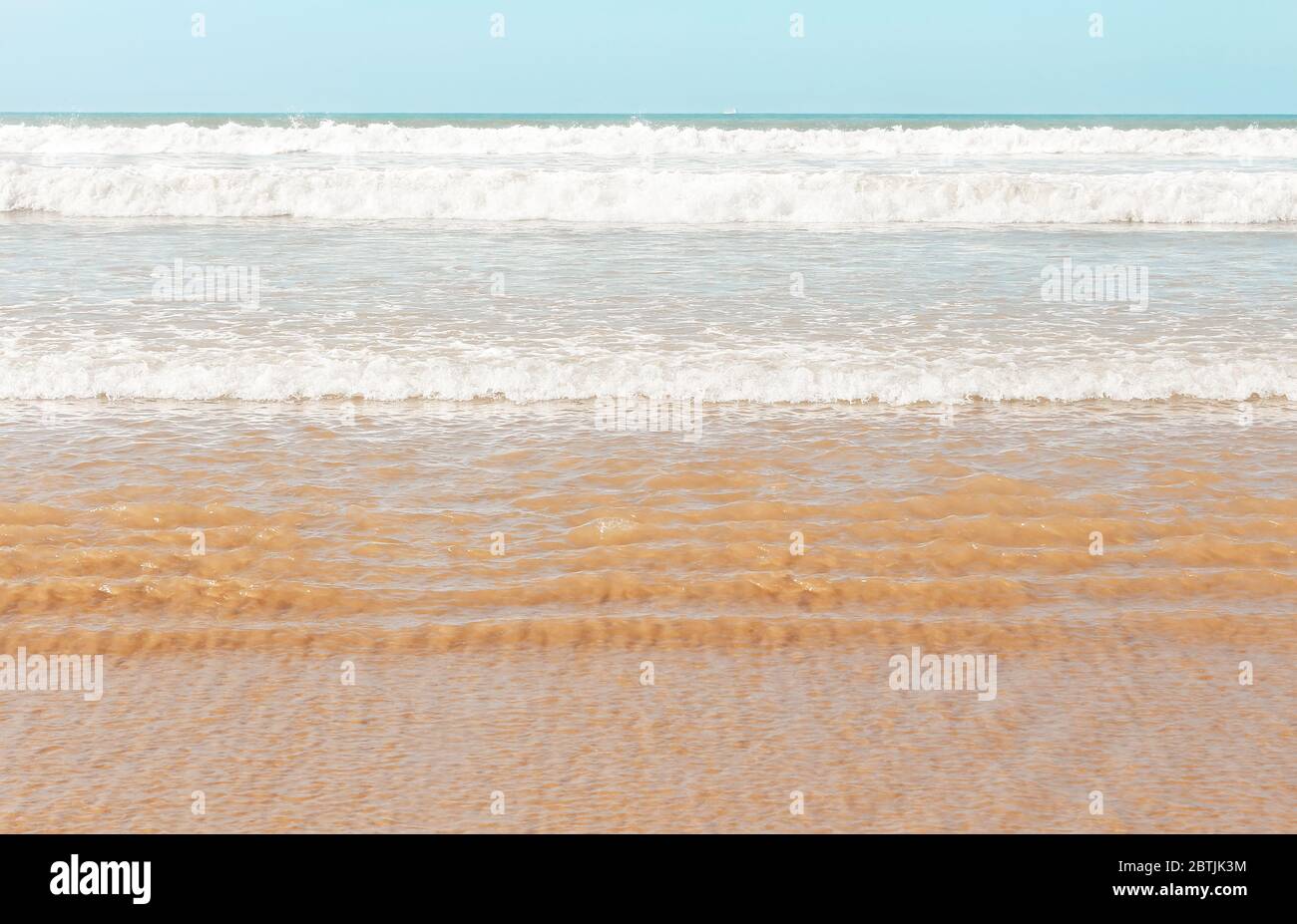 View over sandy beach of Atlantic ocean with waves coming in perfect ...