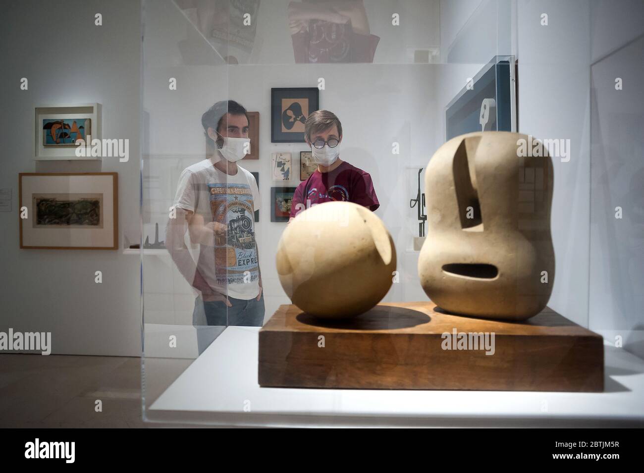 Visitors wearing face masks are seen looking at sculptures of the ...