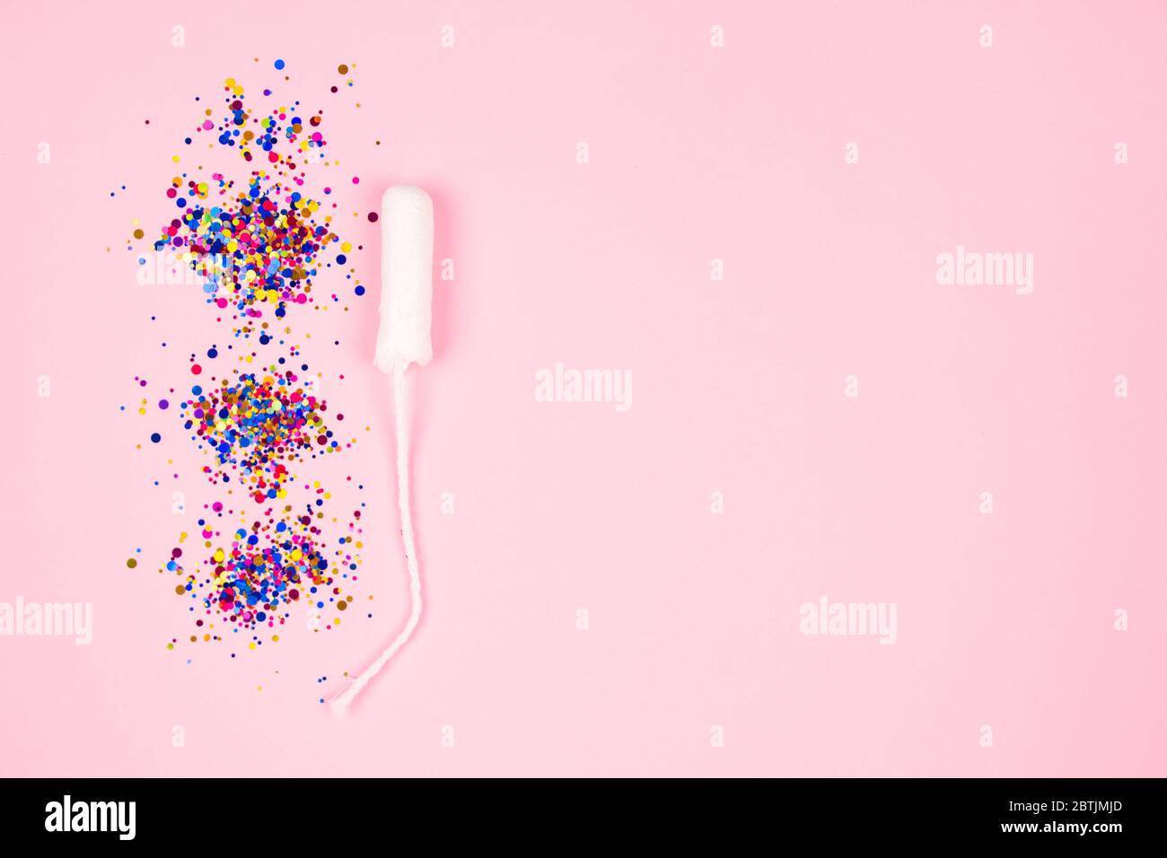 Clean cotton tampon with colorful sparkles on pastel pink background ...