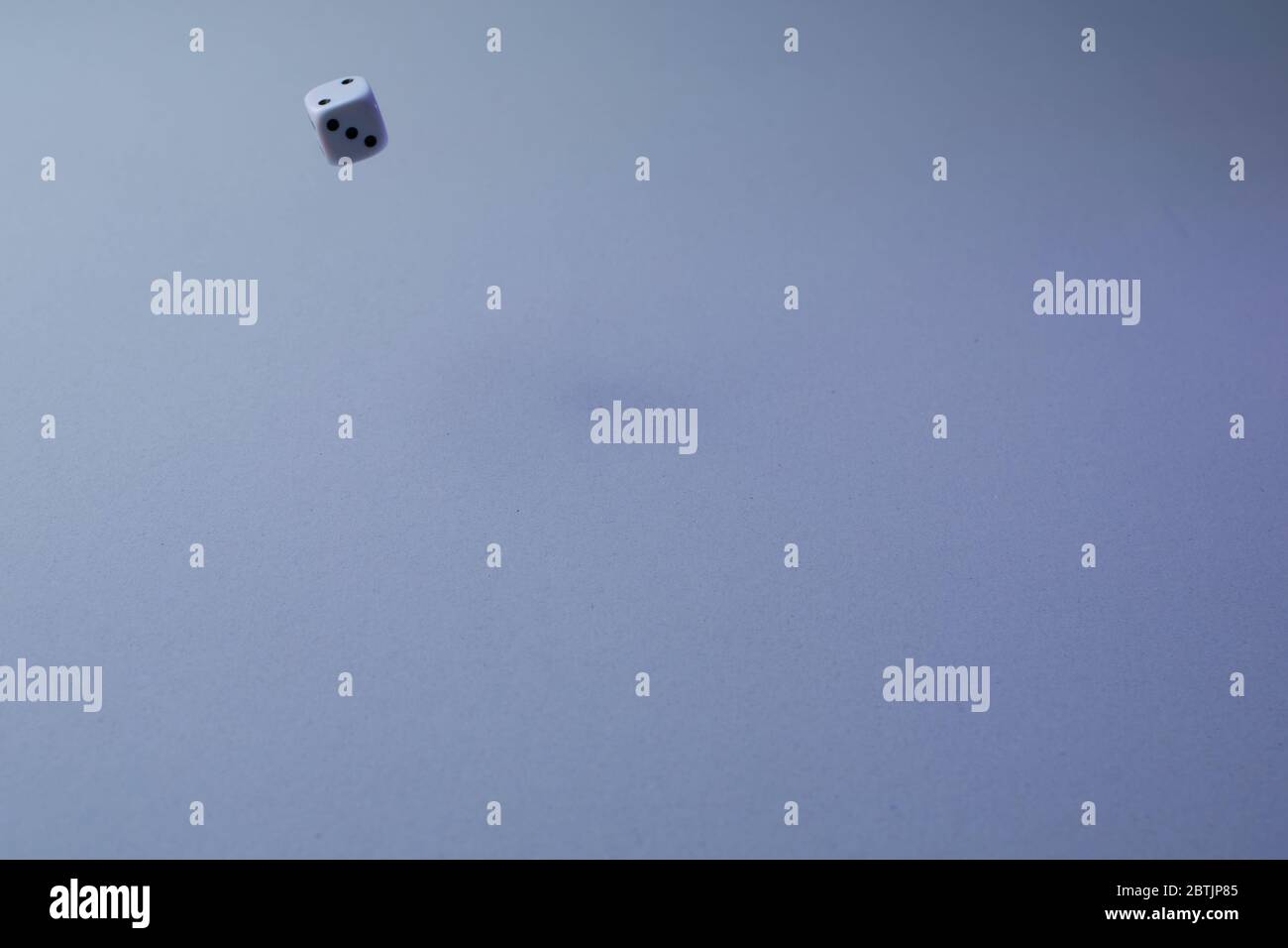 One dice on white background flying, high speed, before hitting the ...
