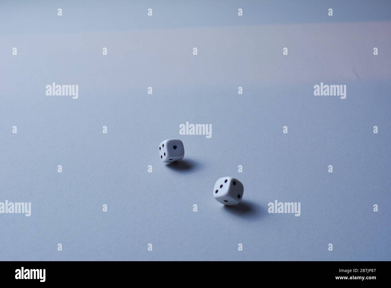 Two dice in motion, on white background, long exposure Stock Photo - Alamy