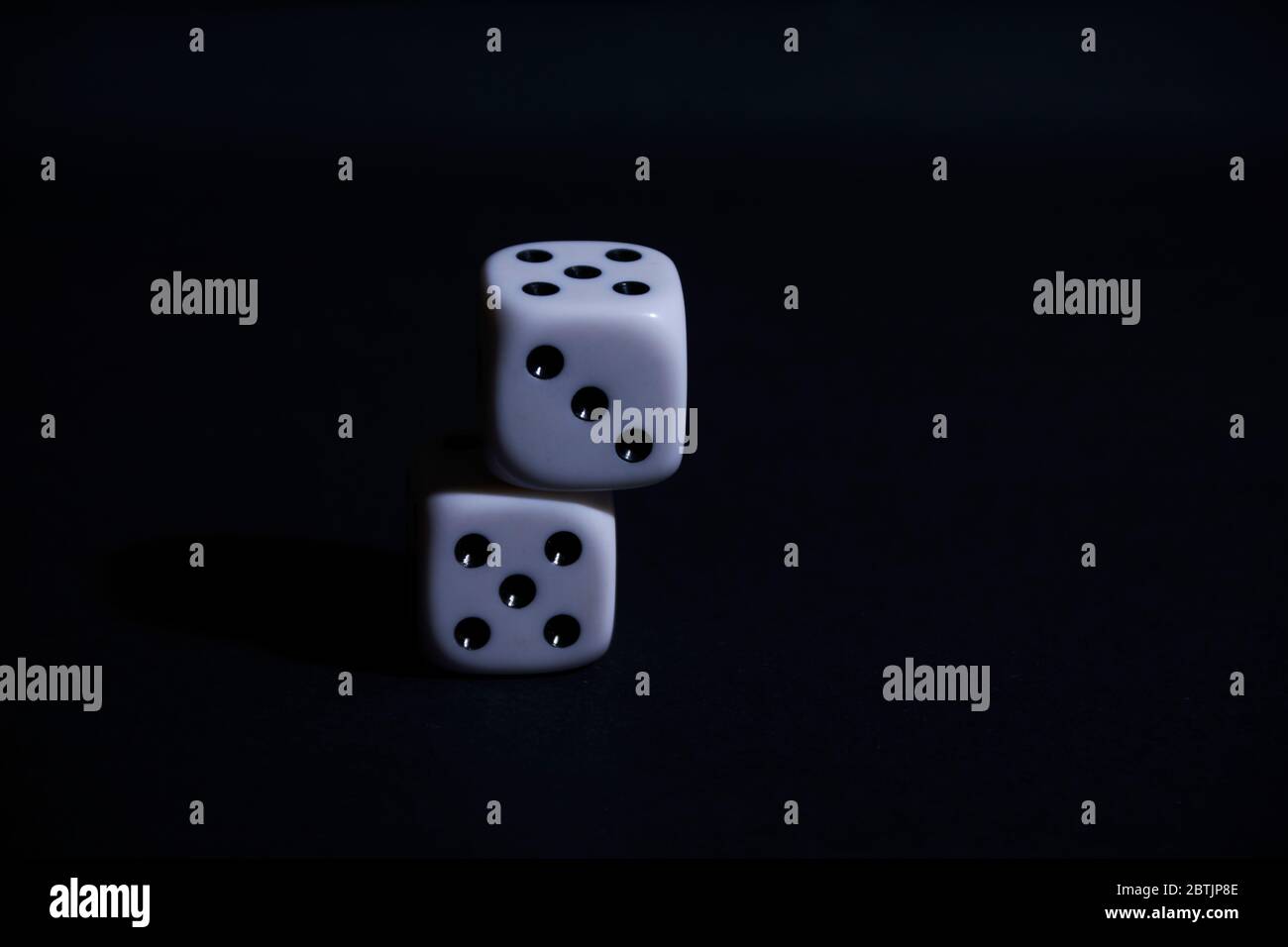 Two dice on black background, Static, horizontal, one on top of the ...