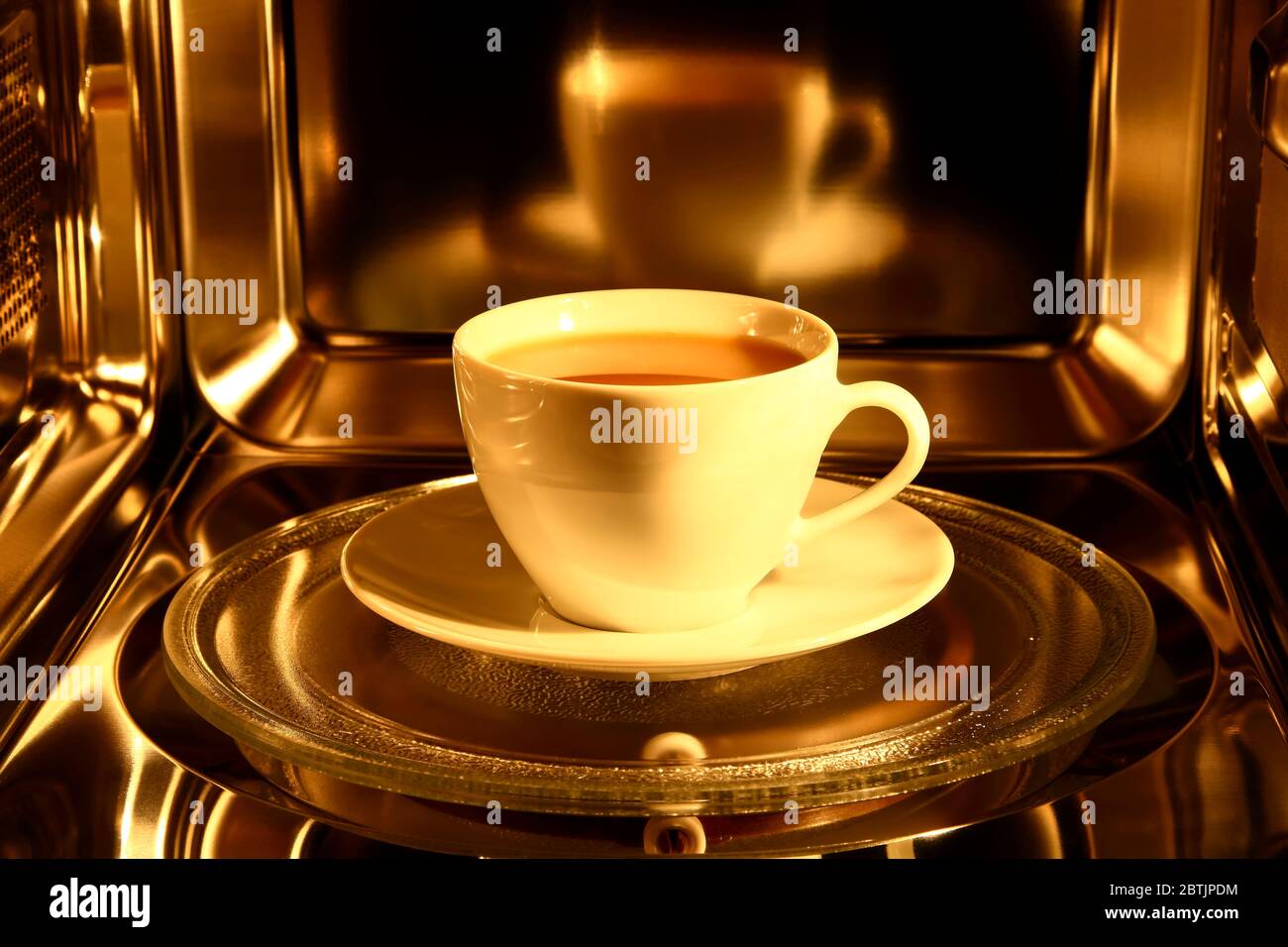 Cup of tea re heating in a microwave oven with enhanced colours using ...