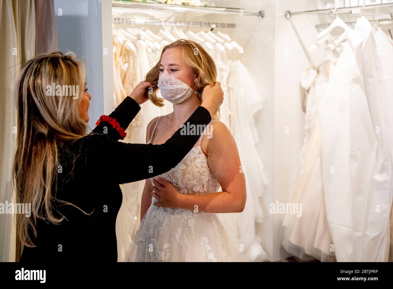 An employer helps a customer to wear a matching facemask to her wedding ...