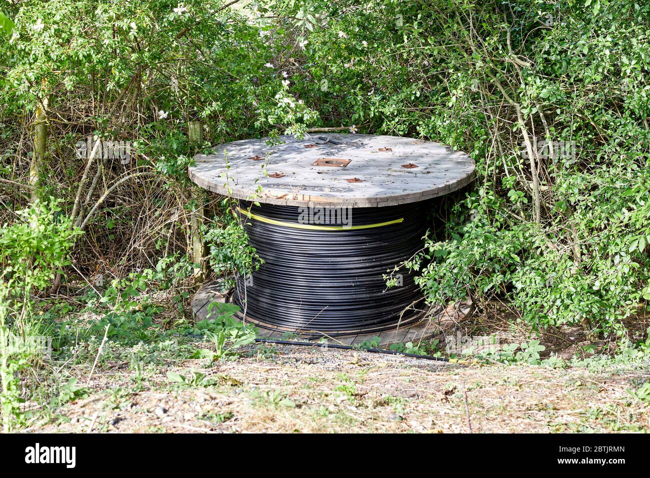 A roll of thick cable dropped by the road side on the verge Stock Photo ...