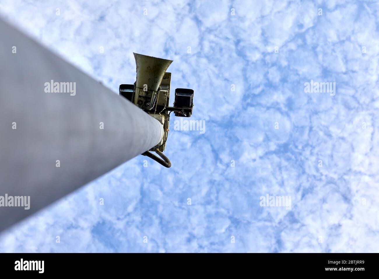 Tall CCTV Camera pole & speaker directly above against blue sky with ...