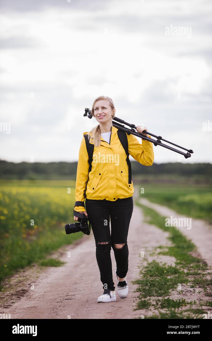 Photographer holding tripod and camera outdoors Stock Photo - Alamy