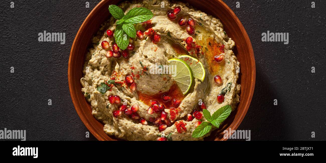 banner of homemade spread of baked eggplant baba ganoush in a bowl with ...